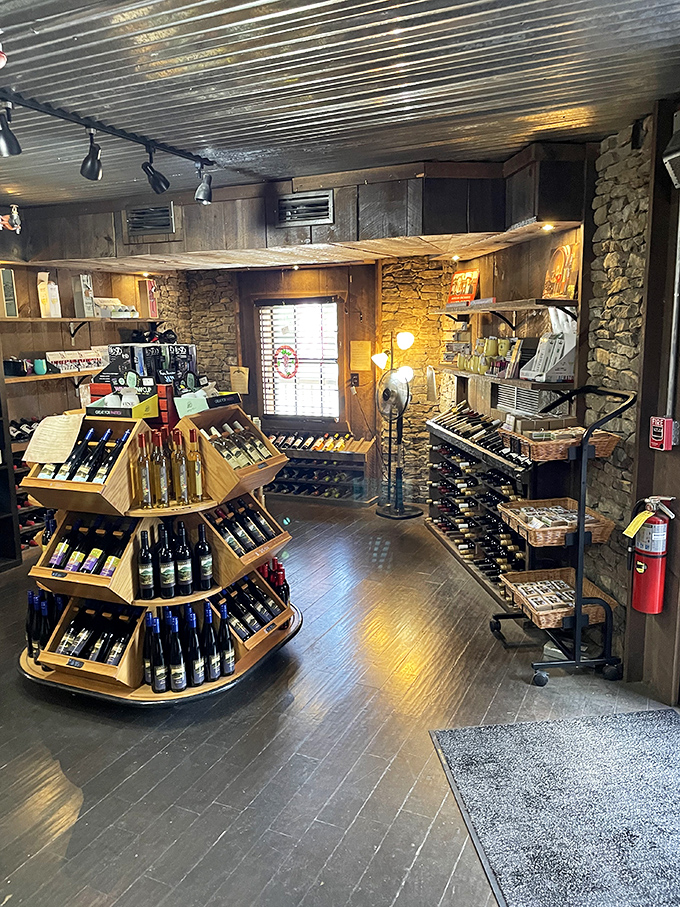 Liquid gold awaits! The winery section features wooden displays of house-made wines and ciders in a cozy, stone-walled space that feels like a mountain hideaway.