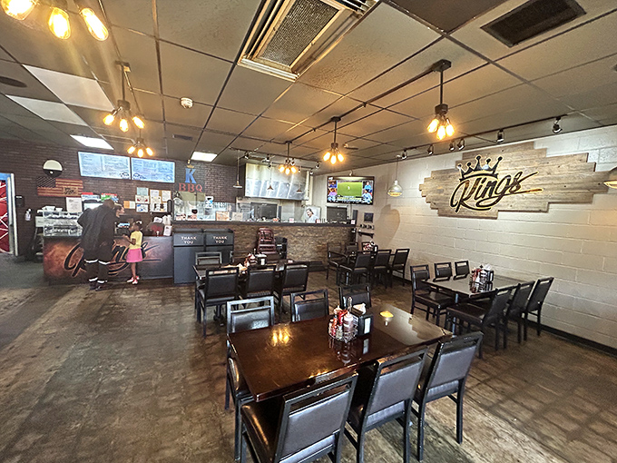 Edison bulbs cast a warm glow over rustic tables where barbecue dreams come true. The crown logo reminds you this is royalty in Oklahoma's meat kingdom.