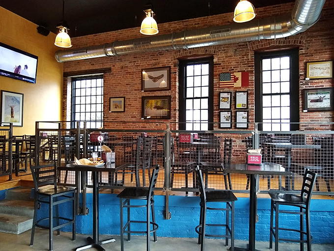 Exposed brick walls, industrial lighting, and that vibrant blue accent wall create the perfect backdrop for burger bliss. Architectural Digest meets comfort food heaven.