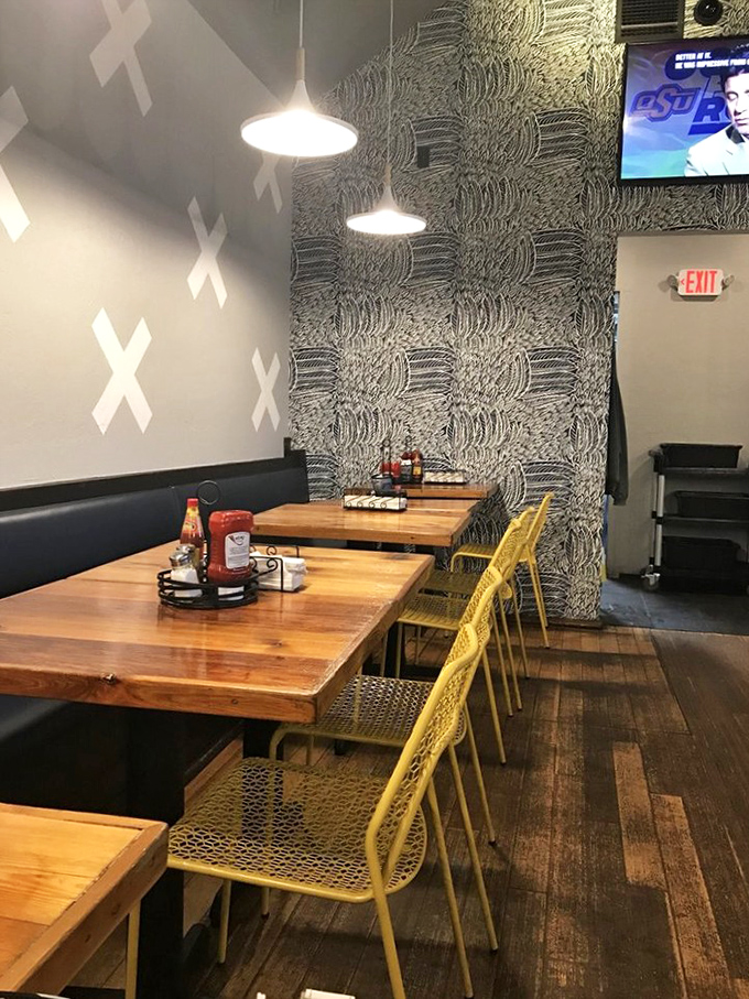 Modern meets comfort inside with wooden tables, yellow chairs, and artful wall patterns. It's like your coolest friend designed a chicken joint.