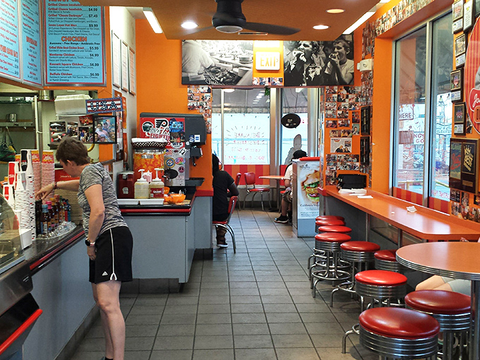 Inside, vibrant orange walls and classic red stools create that perfect nostalgic diner vibe where calories don't count and conversations flow as freely as the soda.
