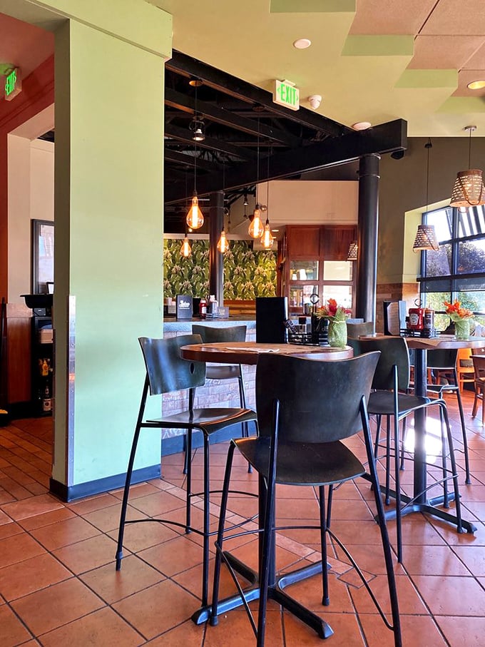 Modern meets Southern comfort inside Julep, where pendant lights cast a warm glow over terracotta floors and botanical wallpaper whispers tales of mint juleps past.