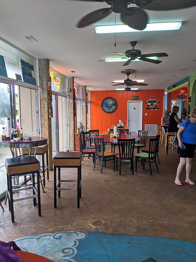 Inside, coral orange walls and spinning ceiling fans create that perfect "I'm officially on vacation" vibe that makes everything taste better.
