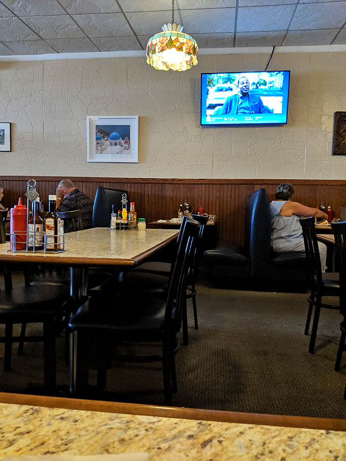 Classic stained-glass lamps hang above tables where countless steak dreams have come true. The wood paneling whispers, "You're among friends now."