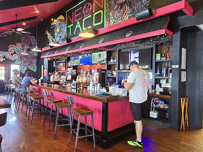 Where Miami Beach meets Midwest charm &ndash; the vibrant bar area pops with pink accents and playful artwork that sets the stage for flavor adventures.