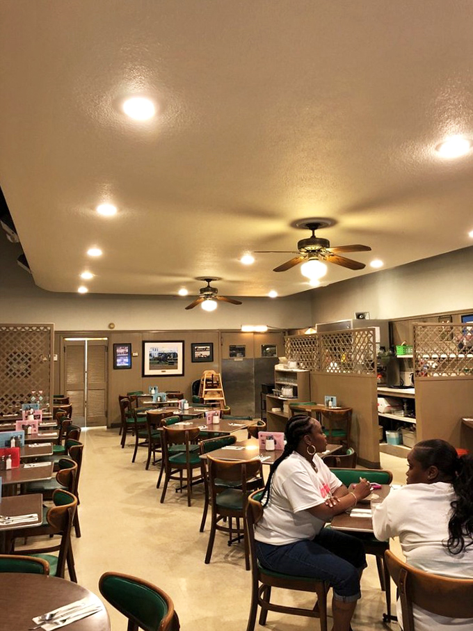 Inside, ceiling fans lazily spin above wooden tables where breakfast dreams come true. The lattice dividers add that touch of vintage charm.