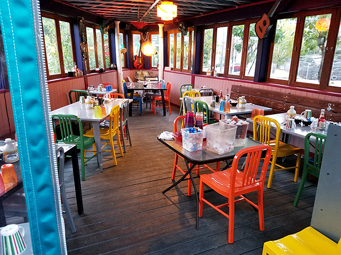 Rainbow-colored chairs jazz up this sunlit dining space, creating the perfect backdrop for morning conversations and coffee refills. 