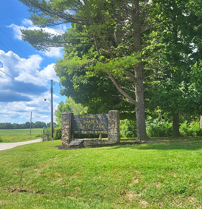 The stone entrance sign stands sentinel, promising adventure beyond. Like the world's most understated theme park entrance, but the thrills inside are all-natural.