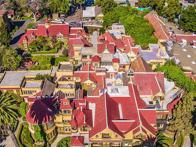 This aerial view reveals the mansion's haphazard expansion – a sprawling puzzle of rooflines and additions that looks like a Victorian-era game of Tetris gone wild.
