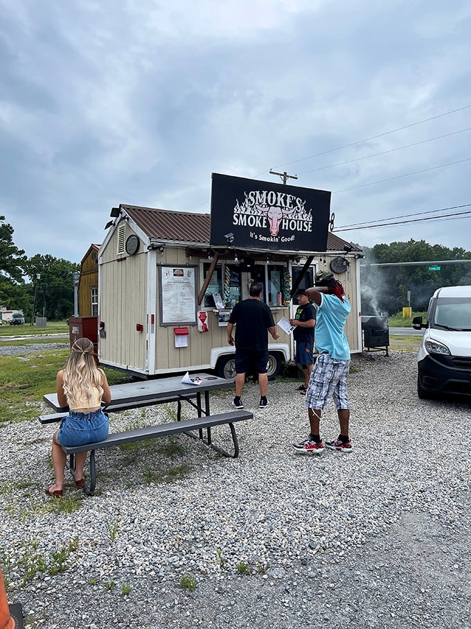 The al fresco dining experience at Smoke's. Simple picnic tables, gravel underfoot, and the promise of meat so good you'll forget you're sitting outside.
