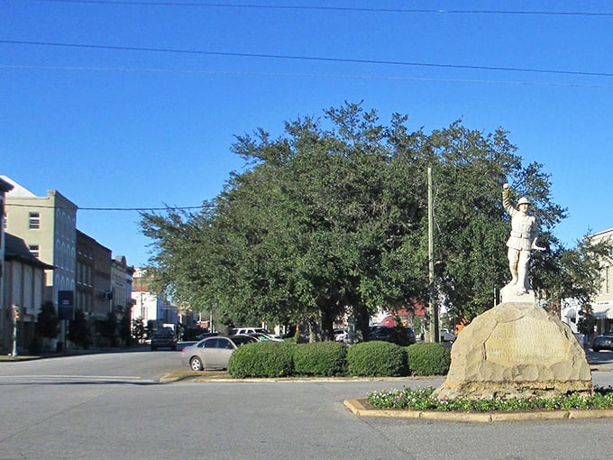 A statue stands sentinel in Eufaula's town center, where massive shade trees have witnessed generations of local history unfold beneath their sprawling branches.