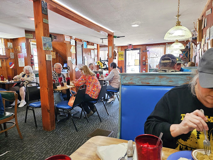 Inside, wood-paneled walls and blue booths create that perfect small-town diner atmosphere where conversations flow as freely as the coffee.