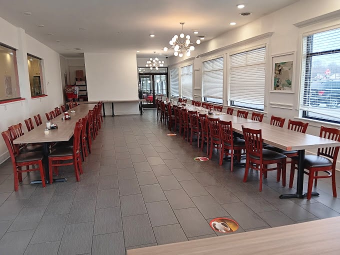 Red chairs stand in perfect formation, like patient soldiers awaiting the breakfast battalion that will soon storm through these doors in search of morning salvation.