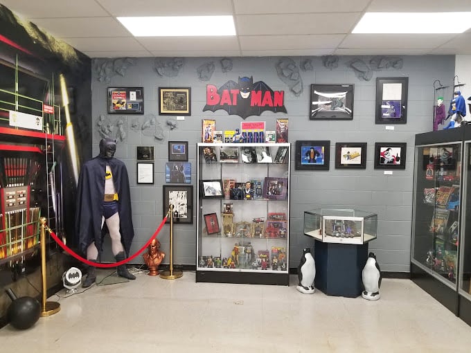 Batman's corner stands guard with vintage memorabilia and collectibles. Those penguin statues aren't just for show - they're keeping watch over decades of Dark Knight history.