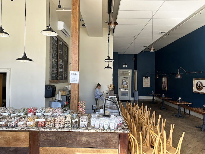 Rustic meets refined in this airy space where wooden beams, navy walls, and pendant lighting create the perfect backdrop for dessert euphoria. 
