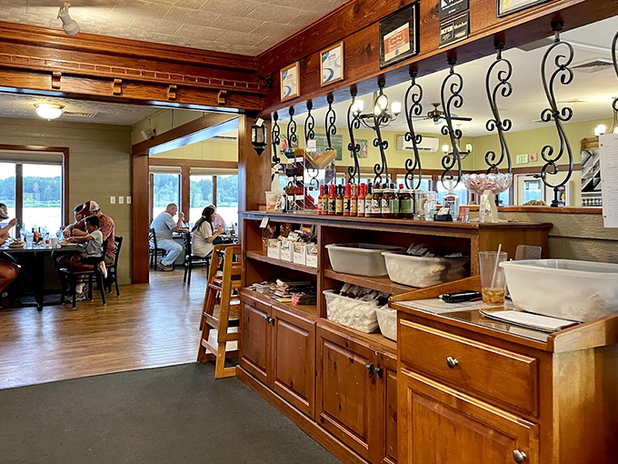 Warm wood paneling and wrought iron details create that perfect small-town atmosphere where conversations flow as freely as the sweet tea.