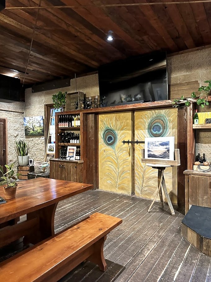 Step inside and time slows down. Wooden benches, peacock-adorned doors, and wine bottles promise an evening where conversations matter more than cell service.
