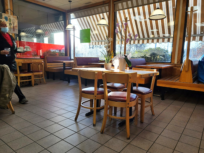 Sunlight streams through striped awnings, casting a warm glow on wooden tables where countless morning conversations have unfolded over steaming coffee cups.