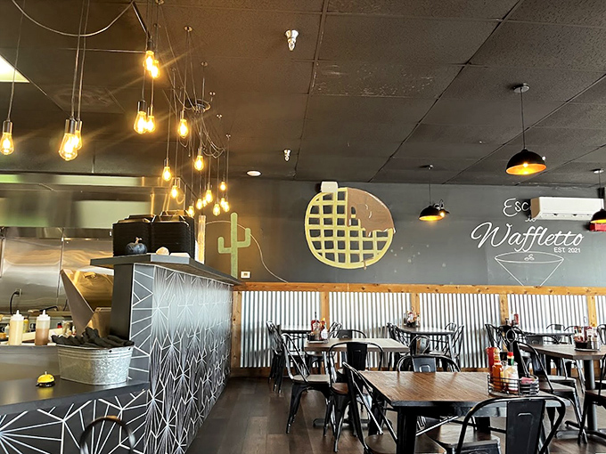 Industrial-chic meets waffle wonderland with exposed bulbs, corrugated metal, and that signature golden waffle logo promising delicious things to come.