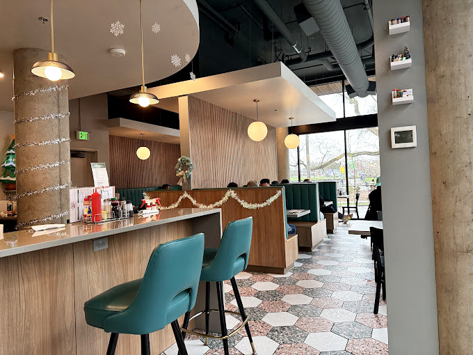 Inside, teal chairs pop against hexagonal tiles and warm wood tones. It's like mid-century modern had a delicious baby with contemporary Seattle style.