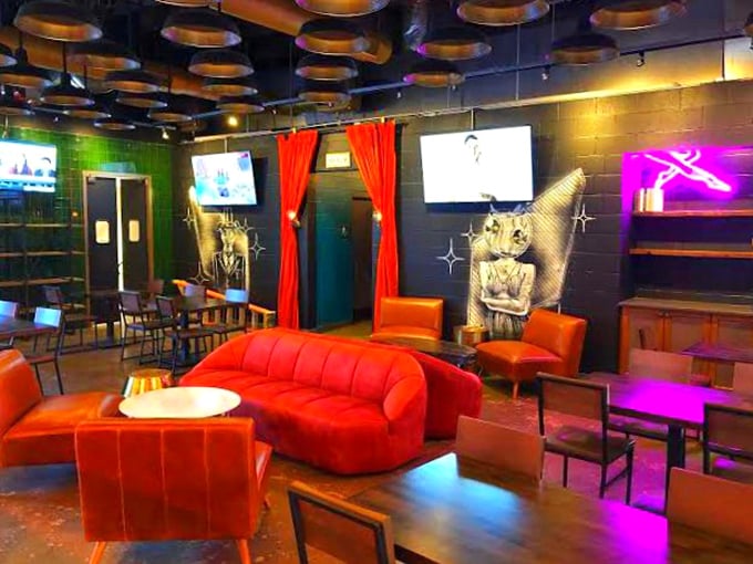 Step into a vibrant space where retro meets modern. Those red couches practically beg you to sink in with a post-brunch food coma.