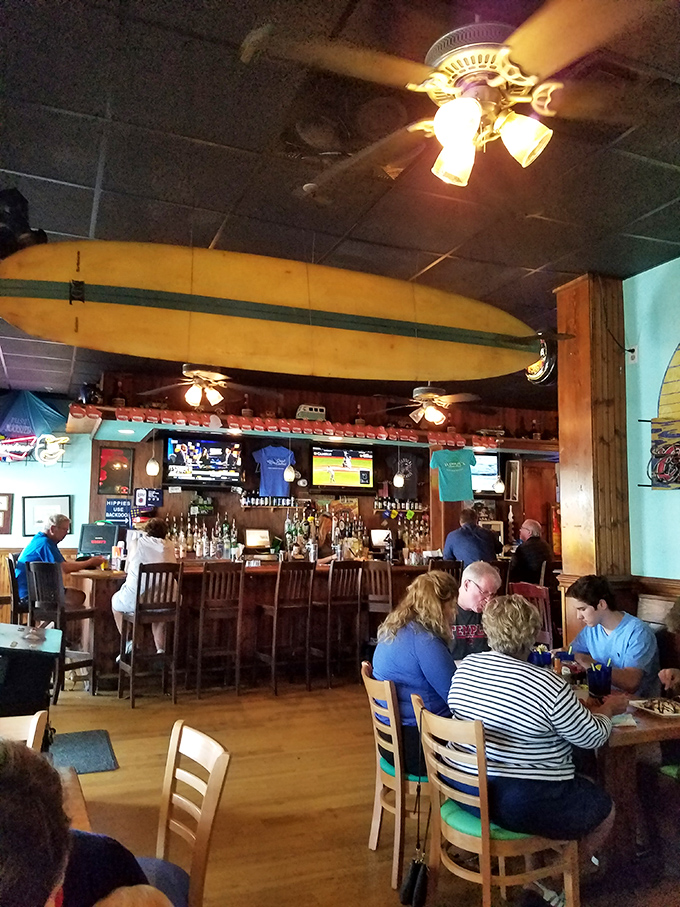 Inside, surfboards hang from the ceiling like trophies of conquered waves, while the well-worn bar promises stories as rich as the food.