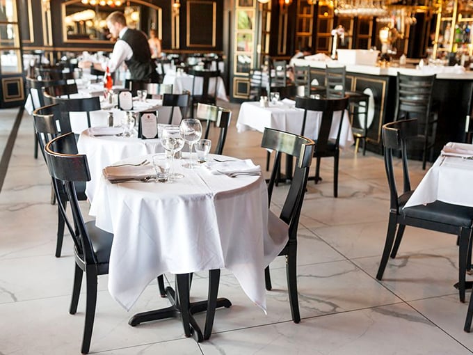 White tablecloths meet sleek black chairs in this elegant dining room where conversations flow as freely as the wine.