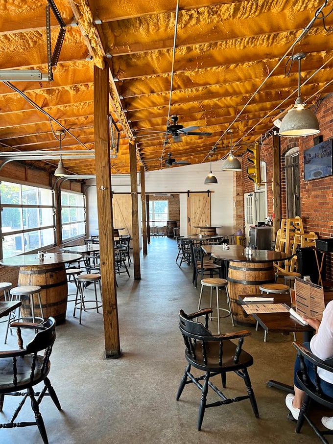 Wooden barrel tables, exposed brick walls, and that honey-colored ceiling create the perfect backdrop for both serious conversations and lighthearted gatherings.