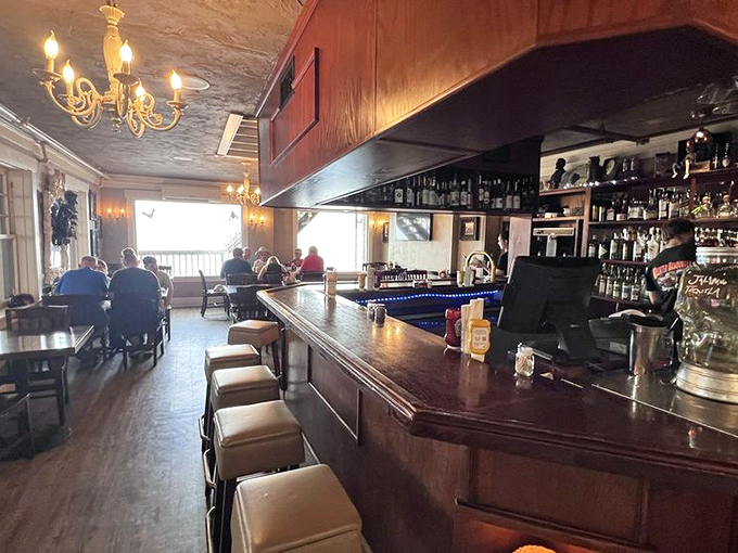 The warm wood-paneled interior with chandeliers creates that perfect "haunted mansion meets cozy tavern" vibe where comfort food meets spectacular views.