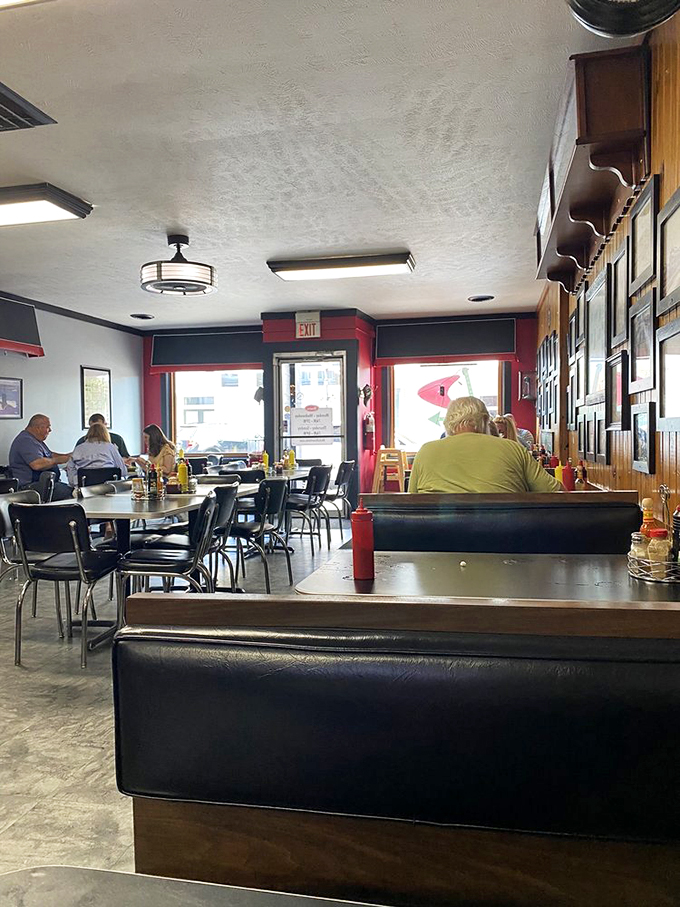 Classic black booths and red accents create that timeless diner atmosphere where conversations flow as freely as the coffee.