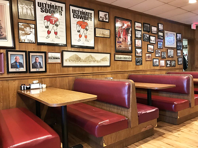 Classic red vinyl booths and wood-paneled walls create the perfect backdrop for comfort food conversations, where Oklahoma sports memorabilia tells stories of local pride.