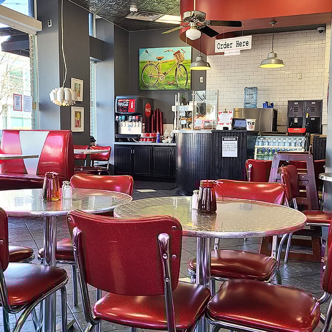 Cherry-red vinyl meets chrome in this retro paradise. The bicycle art whispers, "Stay awhile," while the ceiling fans keep the good vibes circulating.