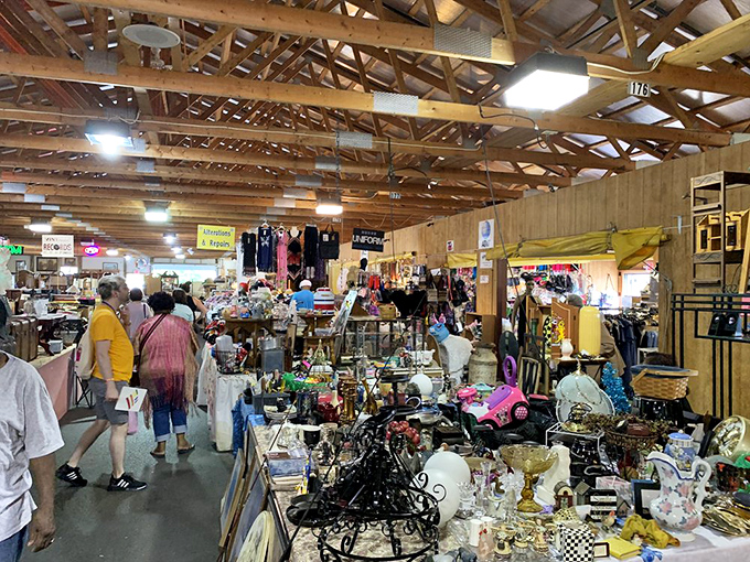 Exposed wooden beams create a rustic cathedral for commerce, where shoppers navigate a maze of collectibles that tell stories of decades past.