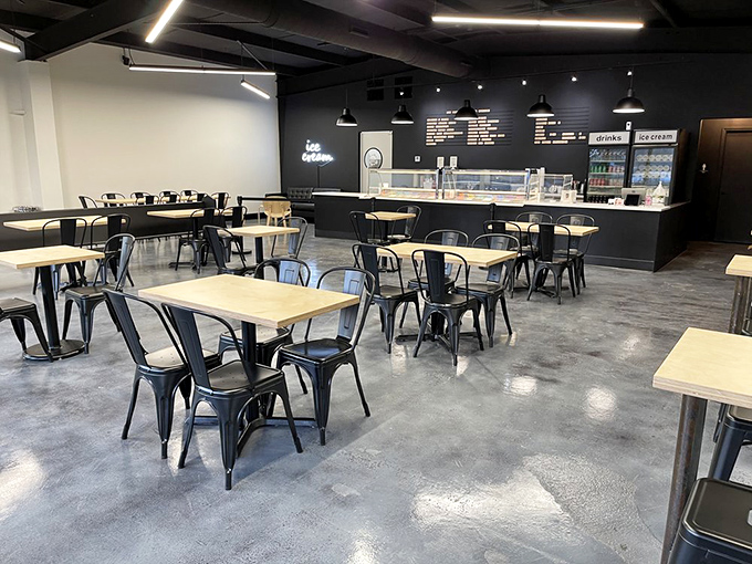 Modern minimalism meets comfort in Area 51's sleek interior. Black walls, wooden tables, and metal chairs create the perfect backdrop for ice cream's starring role. 