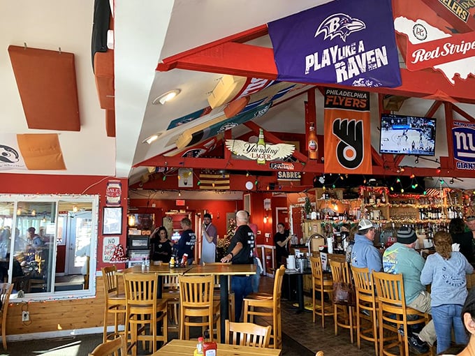 Sports flags wave overhead like festive bunting in a playground for grown-ups. The bar area buzzes with energy that rivals the stadium atmosphere.