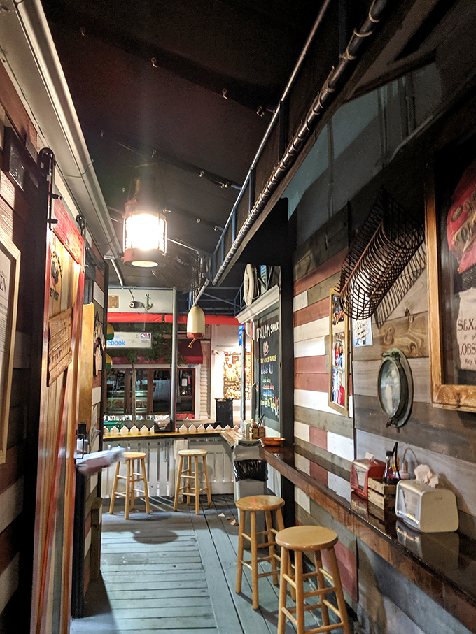 Nautical charm meets seafood perfection in this narrow corridor of culinary delight. Like a submarine designed by someone who really loves wooden stools.