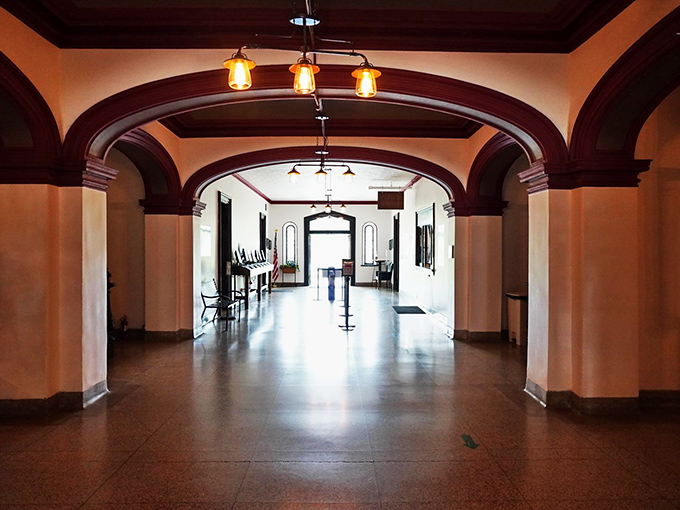 A faded pink common room where patients once gathered, its peeling walls and vintage furniture frozen in time. The windows still frame the outside world patients longed to rejoin. 