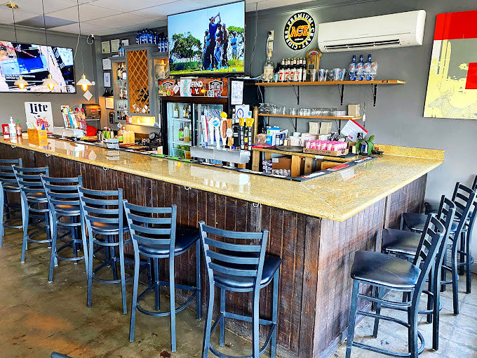 The rustic wood-paneled bar invites patrons to pull up a stool, order a cold one, and settle in for food that transcends typical bar fare.