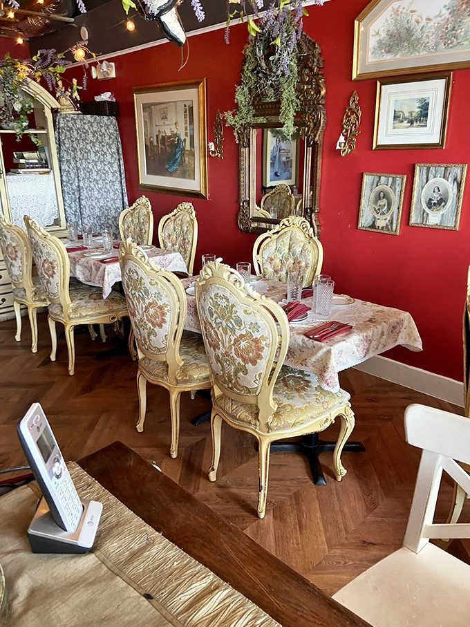 Rich crimson walls adorned with vintage frames create a space that feels like your stylish French grandmother's living room&mdash;if your grandmother had impeccable taste and a flair for the dramatic.