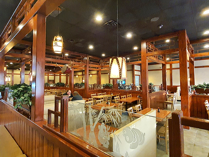 Warm wooden dividers create intimate dining spaces throughout the restaurant, with pendant lighting casting a gentle glow that makes everyone look like they're in a food commercial. 