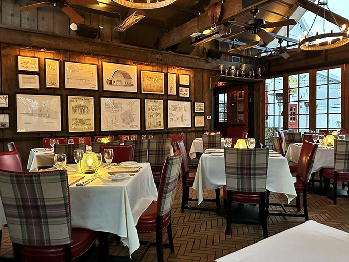 Rustic elegance defined: exposed beams, historical artwork, and plaid-accented chairs create an atmosphere where comfort meets sophistication.