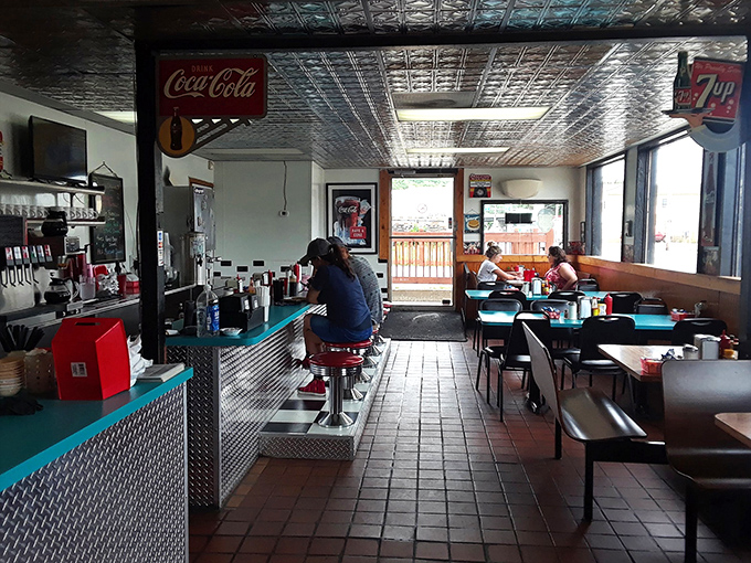 Step inside and time slows down. The pressed tin ceiling, counter seating, and cozy booths create that perfect diner atmosphere where coffee tastes better and conversations flow easier.
