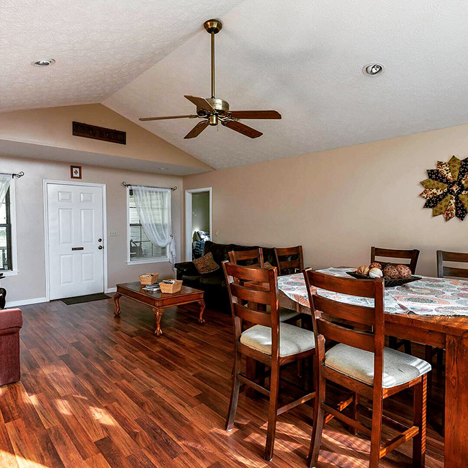 Warm wooden floors that tell stories with every creak, a dining table that promises farm-fresh feasts, and a ceiling fan lazily stirring memories in the making.