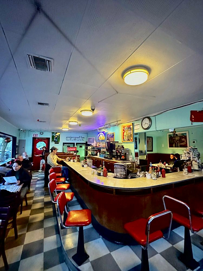 The classic horseshoe counter with vibrant orange stools isn't just seating&mdash;it's front-row tickets to the greatest breakfast show in Portland.