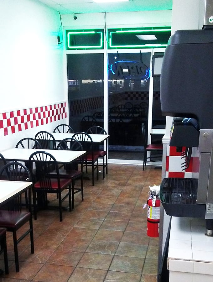 Simple tables, red and white checkered trim, and green neon lighting create an atmosphere where the food, not the decor, takes center stage.