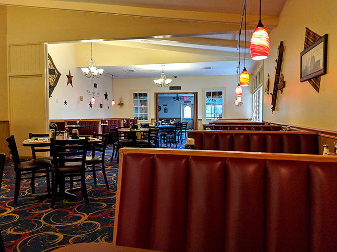 Burgundy booths and colorful pendant lights create that "everybody knows your name" atmosphere. The carpet pattern? Pure diner magic that somehow works perfectly.