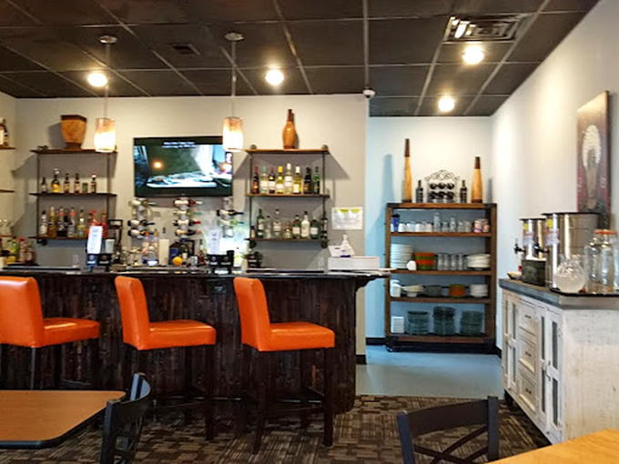 The bar's vibrant orange seats pop against dark wood like sunrise against the night sky. This isn't just a place to eat&mdash;it's where breakfast dreams materialize.