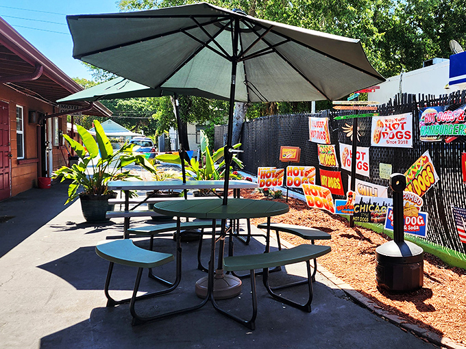 Al fresco dining, Florida-style. These humble picnic tables under shade umbrellas become the stage for some of life's simplest yet most profound pleasures&mdash;like the perfect hot dog on a sunny afternoon.