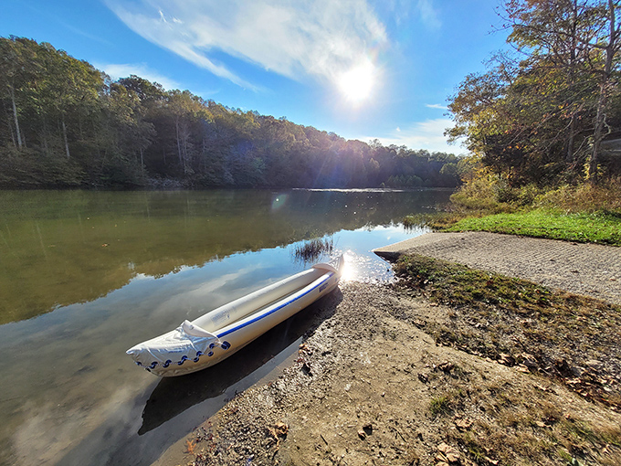 Sunlight dances across Carter Caves' tranquil waters, where a lone canoe waits for the day's adventure to begin. Photo credit: <a href="https://www.google.com/maps/contrib/101564248558187383633/photos/@37.6603208,-99.46416,2823921m/data=!3m2!1e3!4b1!4m3!8m2!3m1!1e1?entry=ttu&g_ep=EgoyMDI1MDQxNC4xIKXMDSoASAFQAw%3D%3D" target="_blank" rel="noopener noreferrer">Bonnie Bogdan</a>