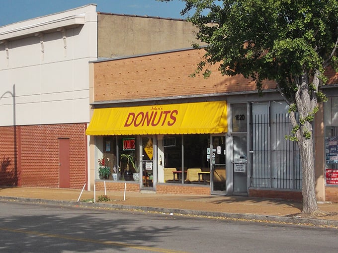 That sunshine-yellow awning isn't just cheerful &ndash; it's a beacon for serious donut lovers seeking authenticity in every bite.